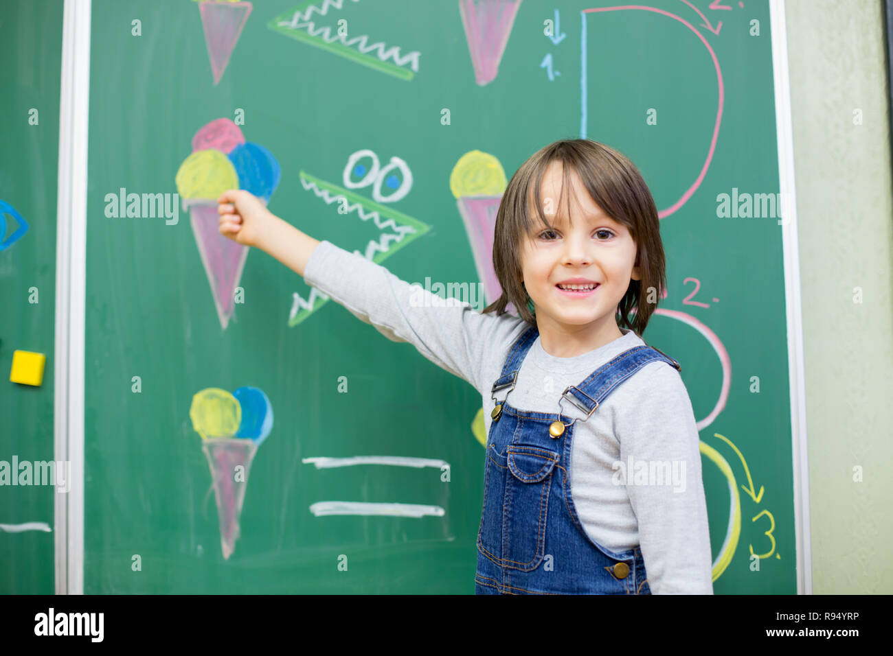 First grade boy at school, showing numbers and calculating in front of ...