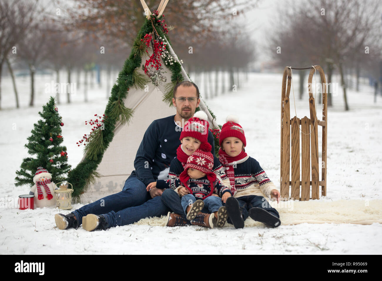 Happy family with kids, having fun outdoor in the snow on Christmas ...