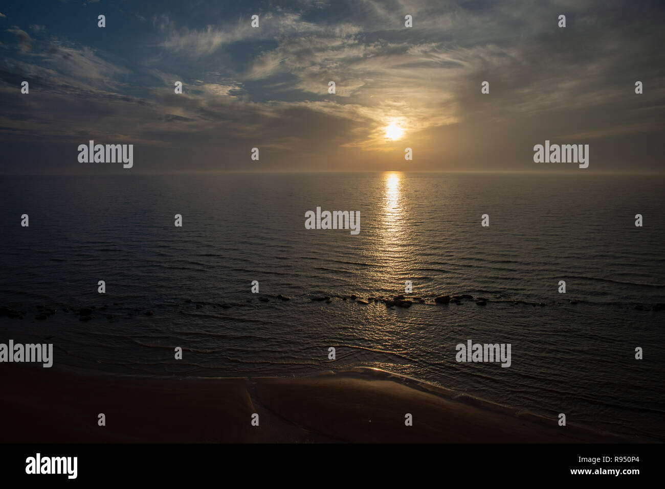 dramatic high contrast clouds in sunset over seaside beach with sand ...