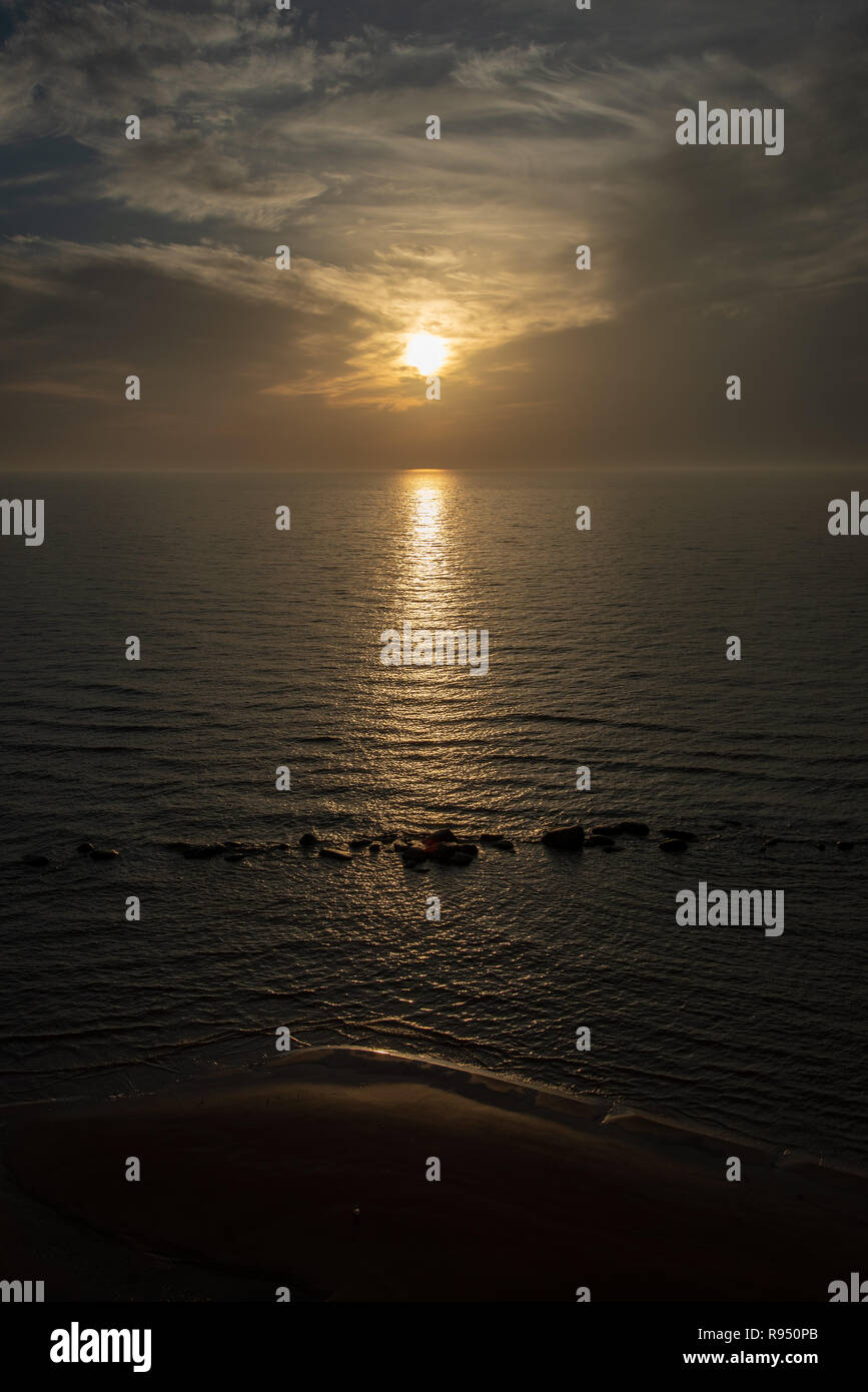 dramatic high contrast clouds in sunset over seaside beach with sand ...