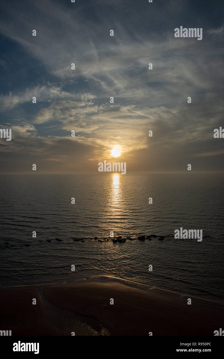 dramatic high contrast clouds in sunset over seaside beach with sand ...