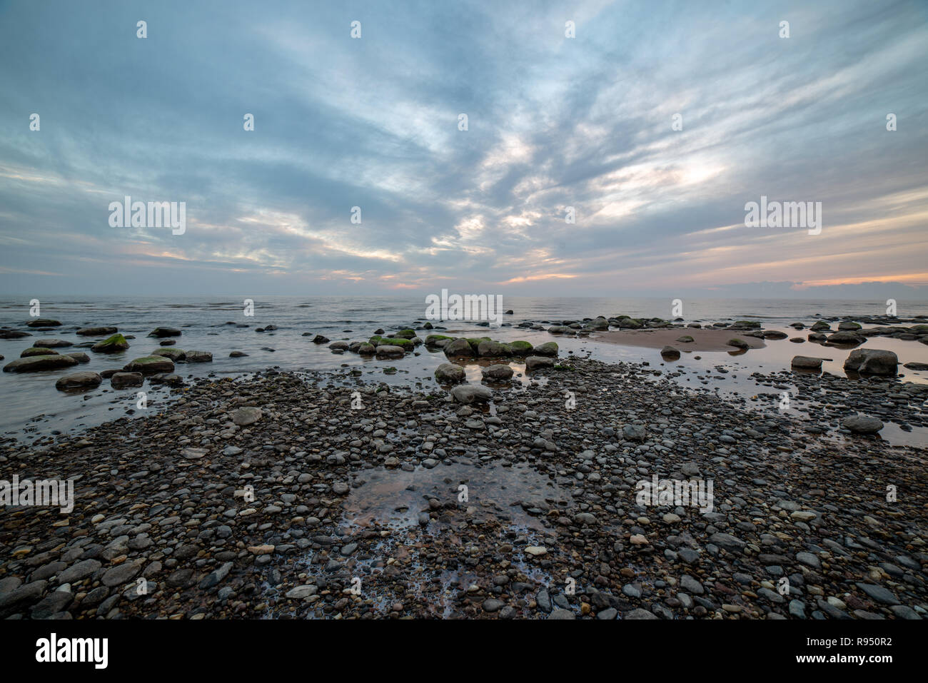 dramatic high contrast clouds in sunset over seaside beach with sand ...