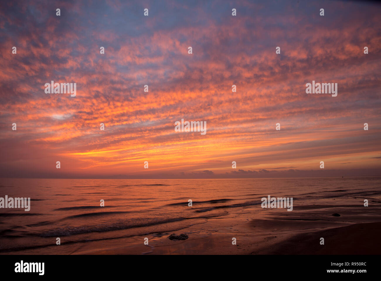 dramatic high contrast clouds in sunset over seaside beach with sand ...