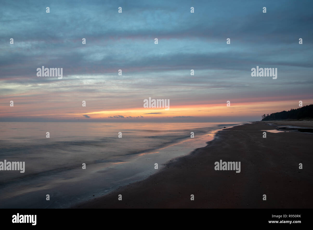 dramatic high contrast clouds in sunset over seaside beach with sand ...