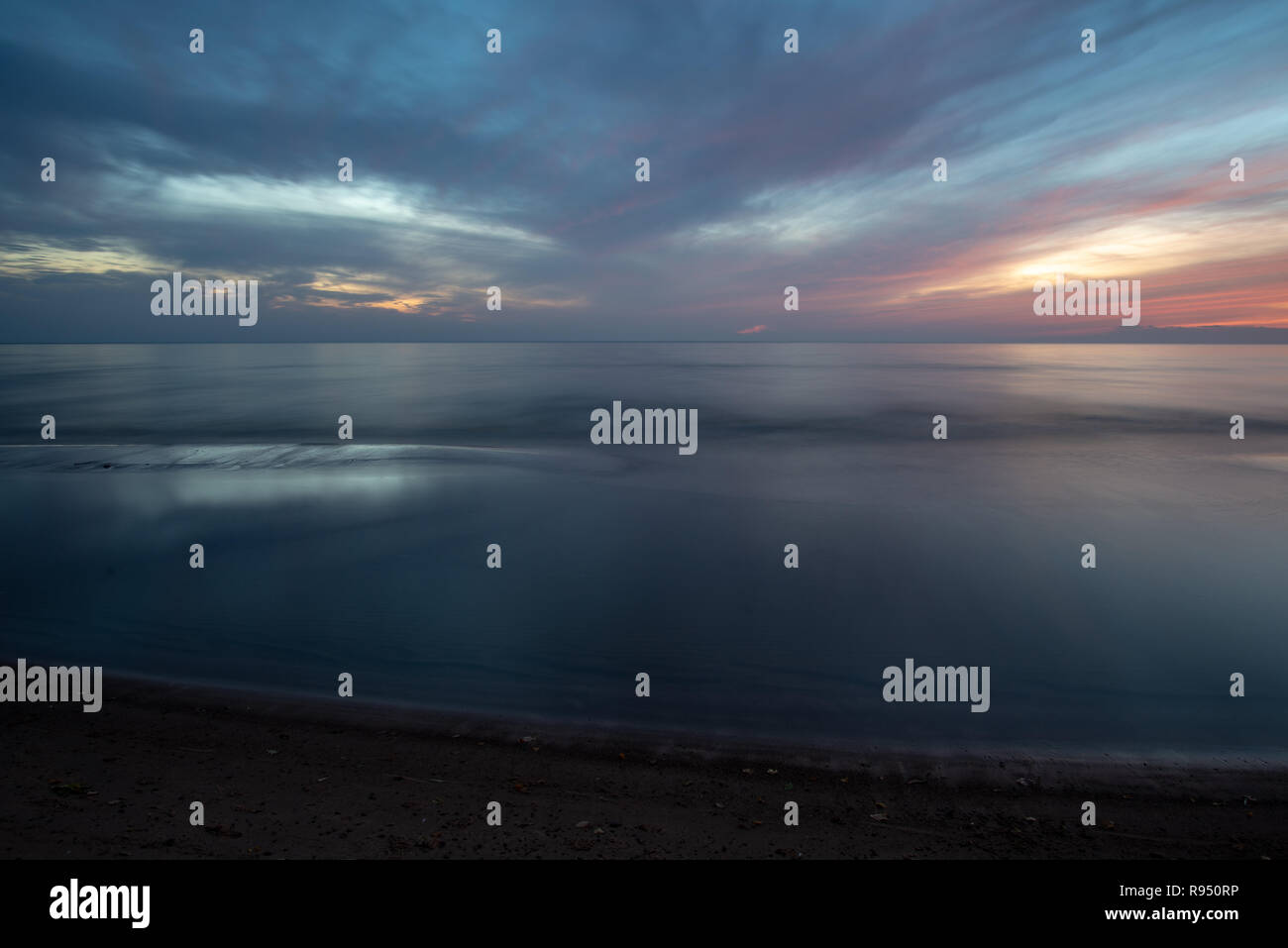 dramatic high contrast clouds in sunset over seaside beach with sand ...