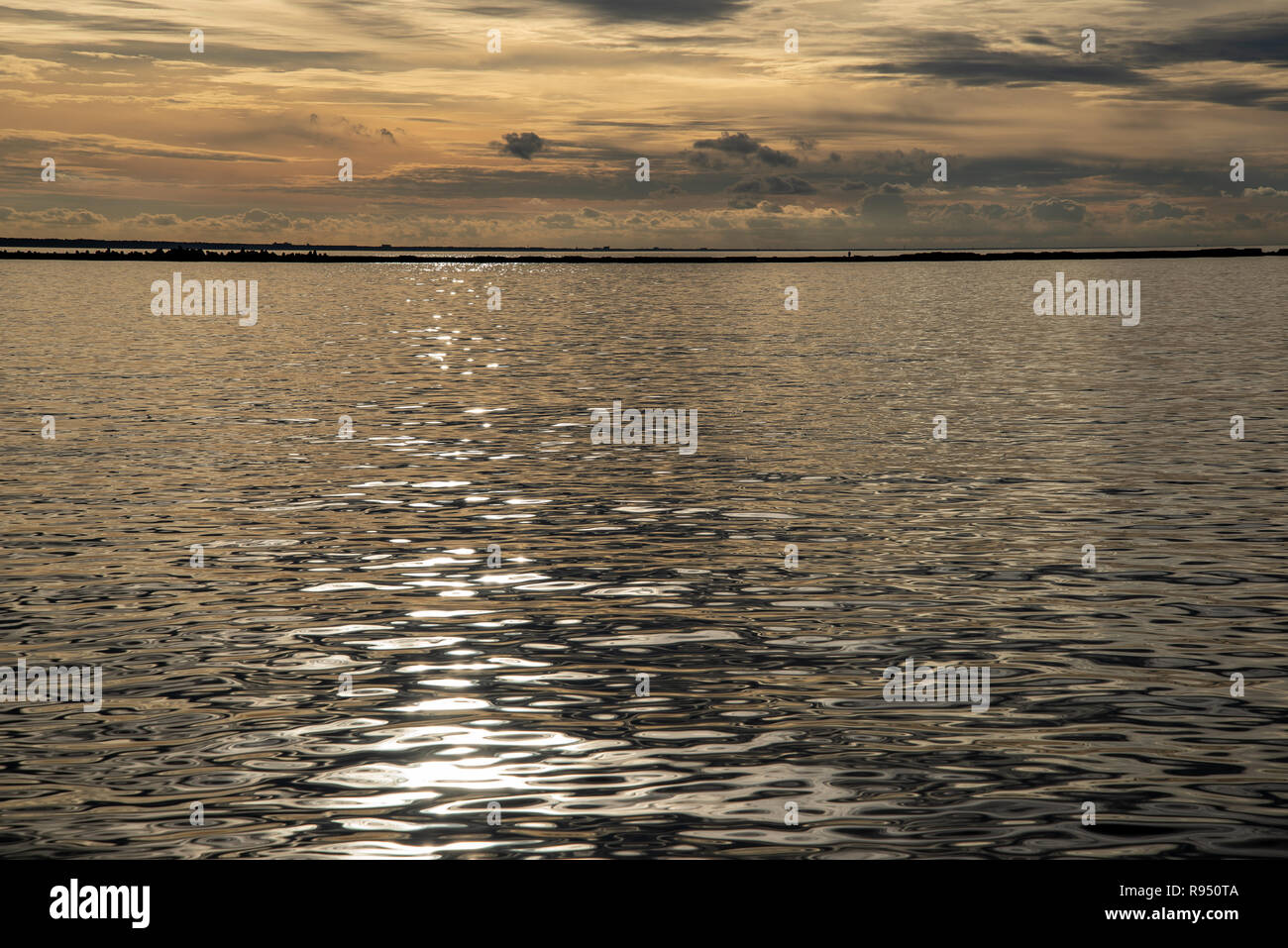 dramatic high contrast clouds in sunset over seaside beach with sand ...