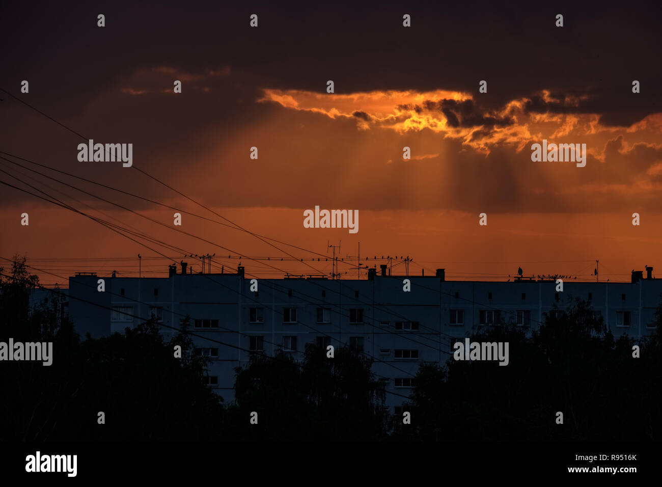 dramatic clouds on red sky over city roof tops at sunset Stock Photo ...