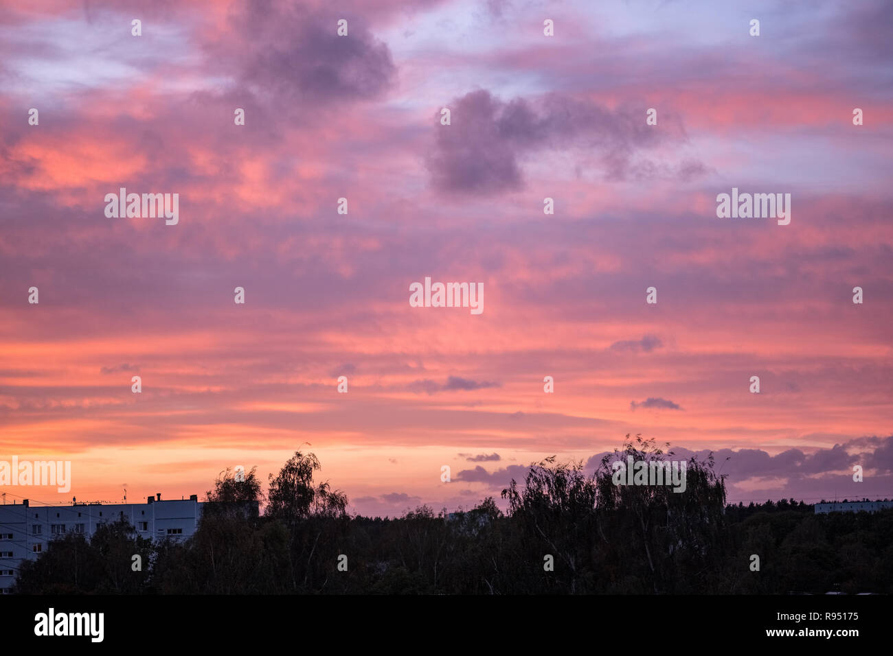 dramatic clouds on red sky over city roof tops at sunset Stock Photo ...