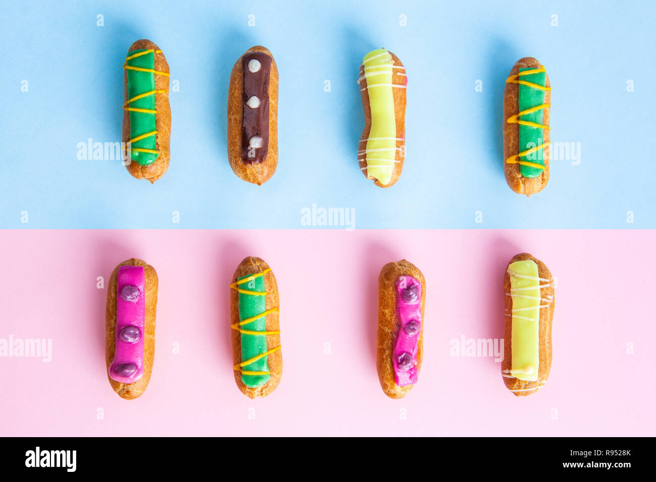 Rows of decorated French eclairs on pink and blue backgrounds Stock ...