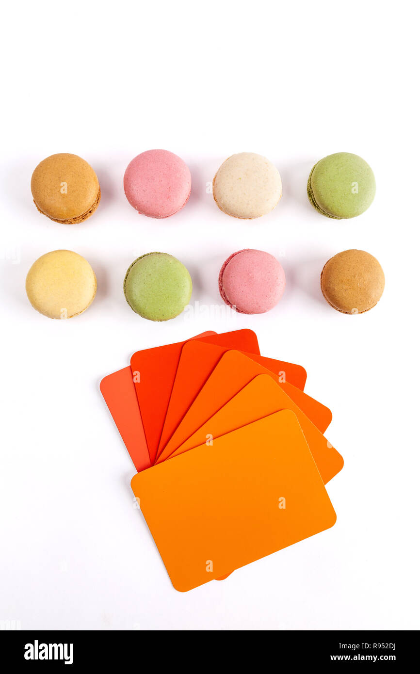 Colorful French macarons with color swatches in red orange hues. Top ...