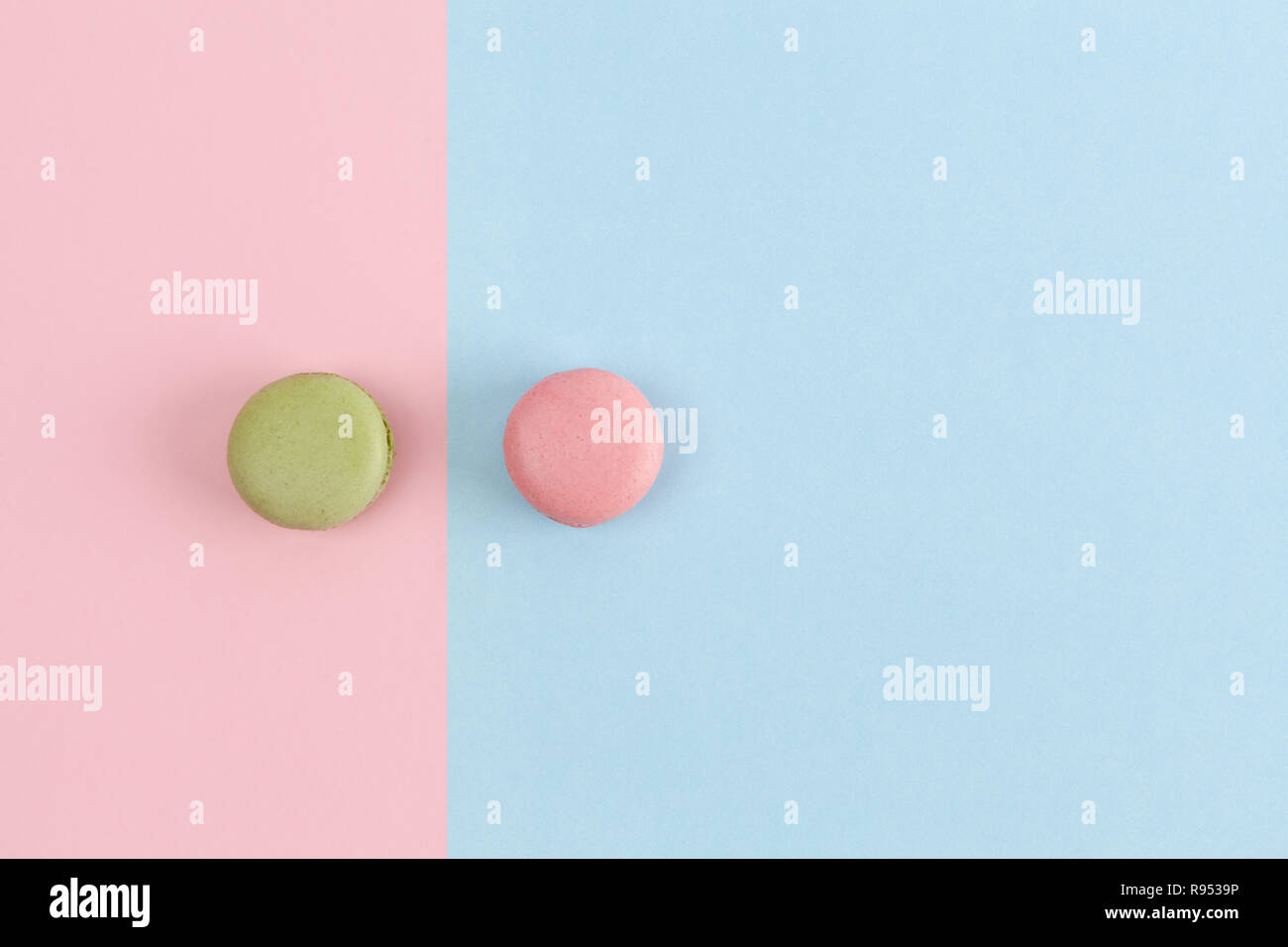 Two macarons on divided background in pastel colors. Top view with copy ...