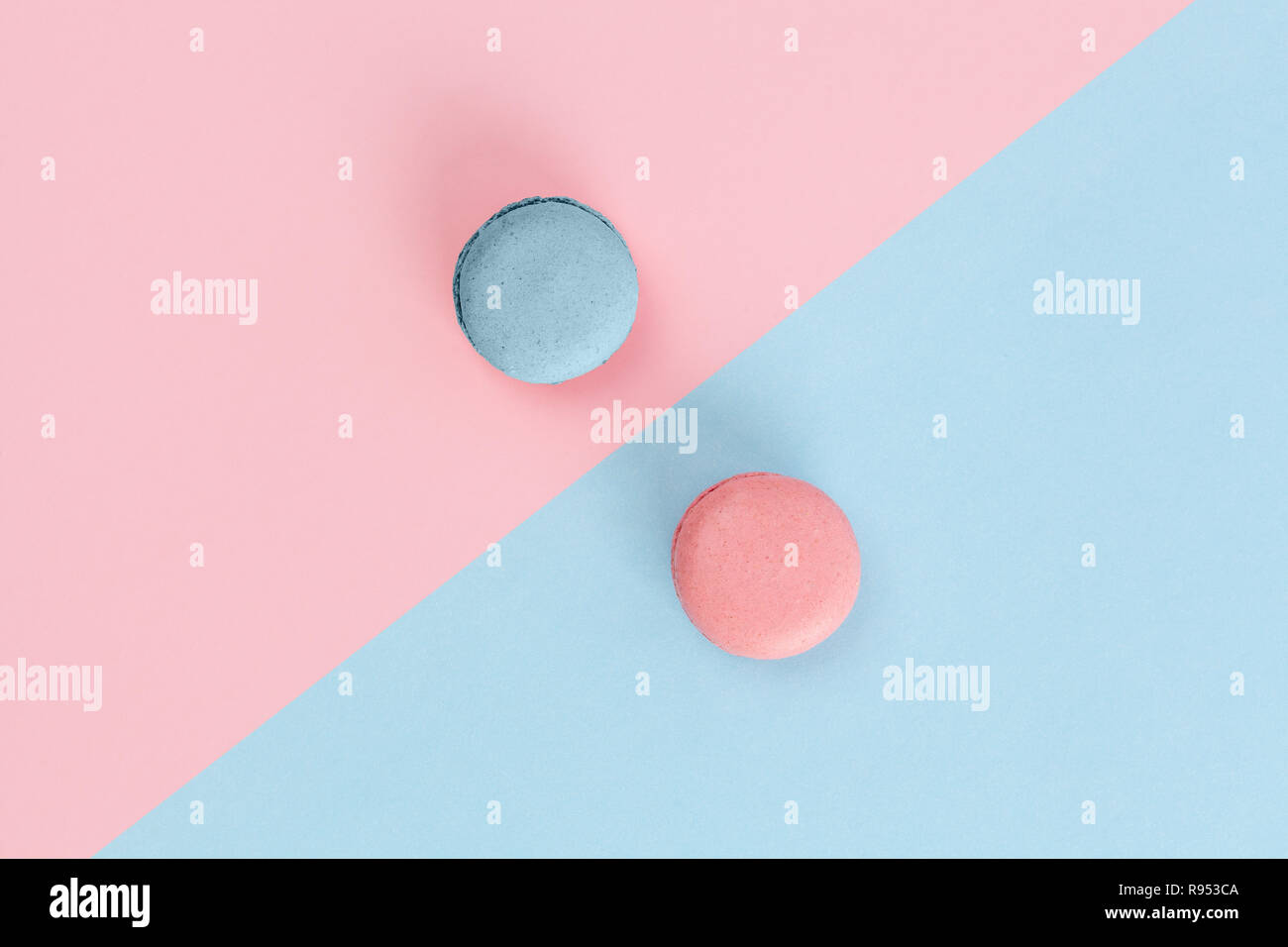 Pink and blue macarons on diagonally divided background in pastel ...