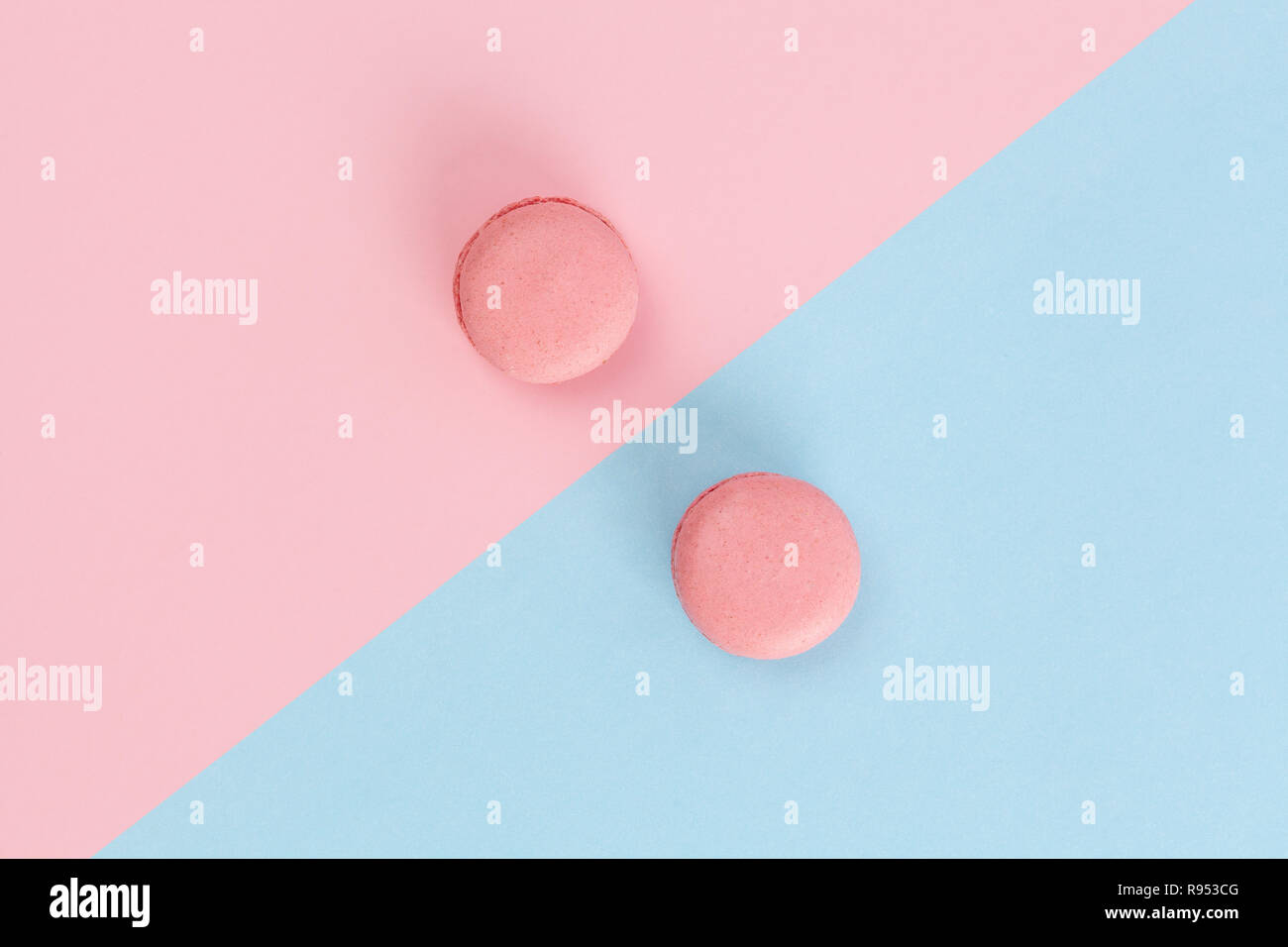 Two pink macarons on diagonally divided background in pastel colors ...