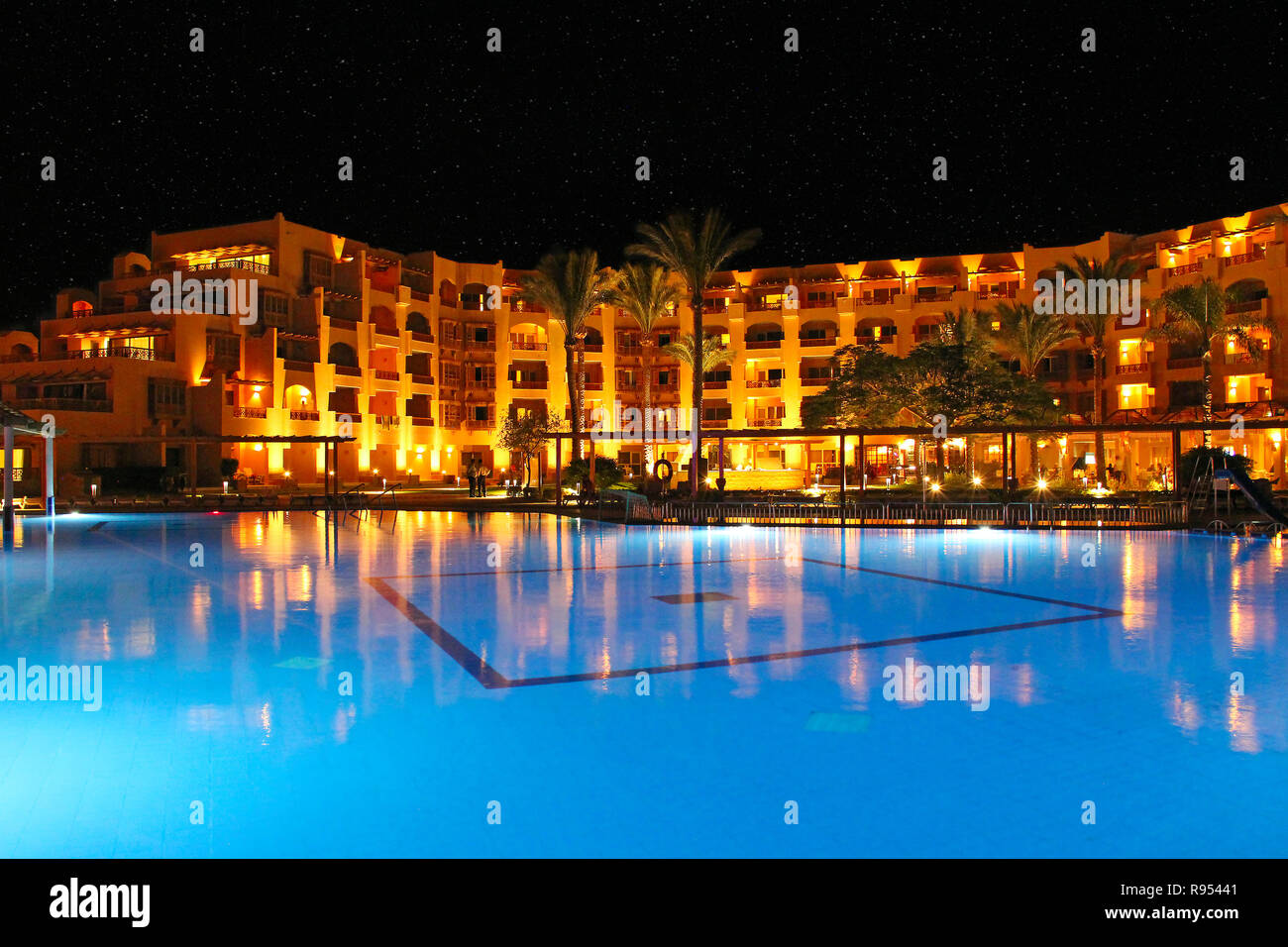 Pool and evening hotel on vacation. People relax by evening near pool ...