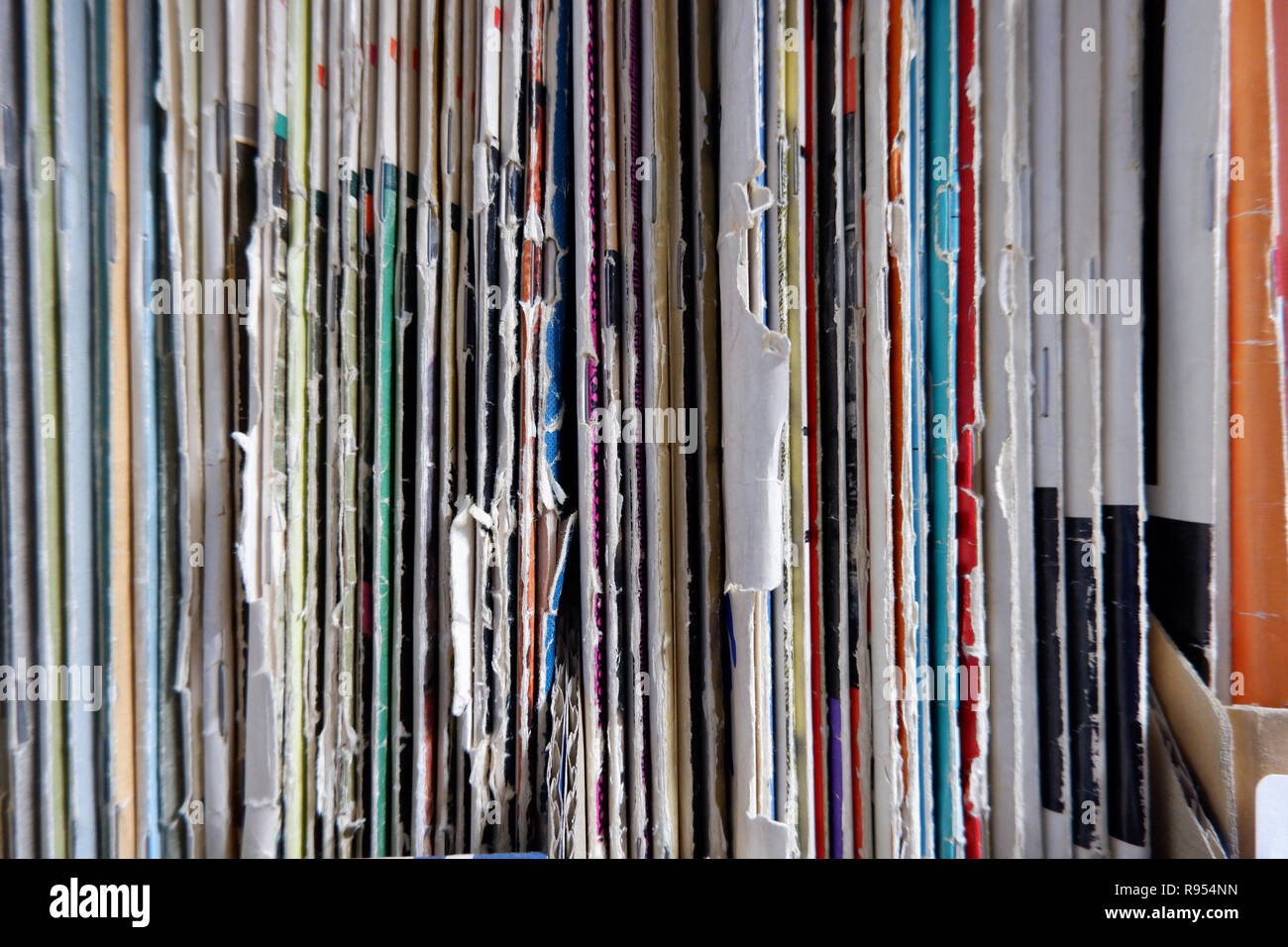 A pile of old worn magazines stacked on a shelf Stock Photo - Alamy