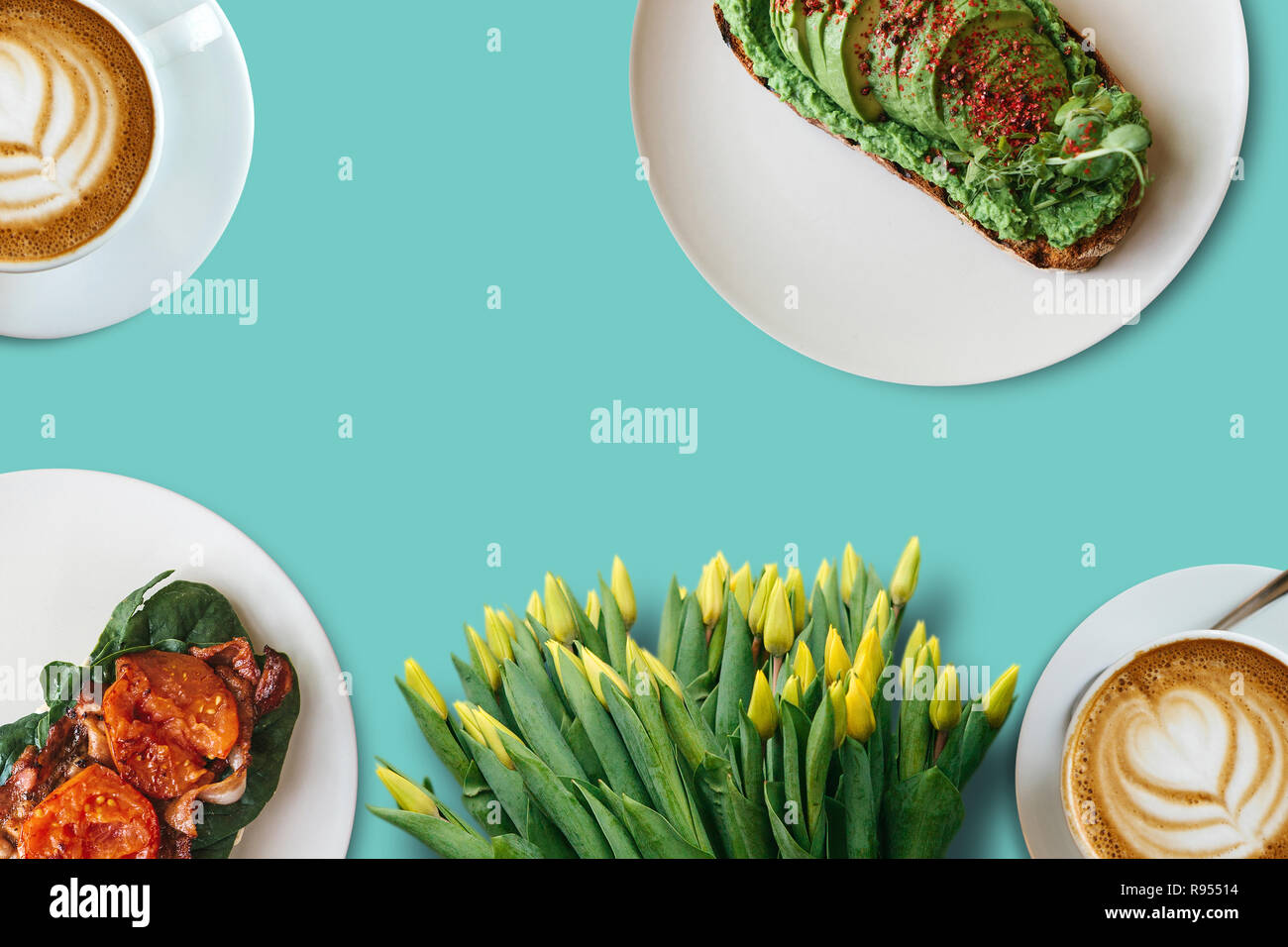 Two cups of coffee, sandwiches and a bouquet of flowers on a bright ...