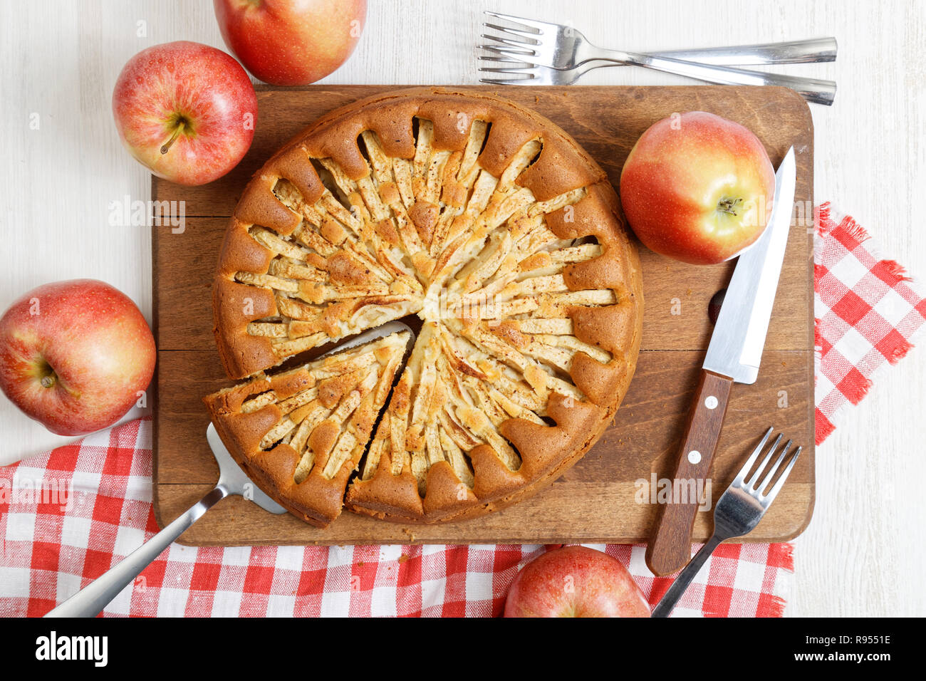 Homemade apple pie topped with slices of apples and cinnamon on wooden ...