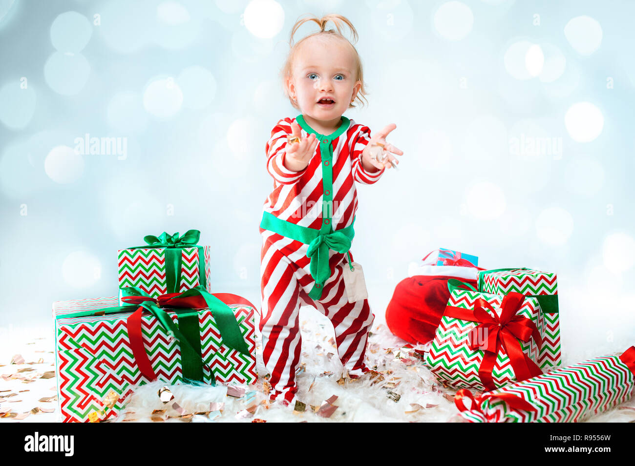 Cute baby girl 1 year old wearing santa hat posing over Christmas ...