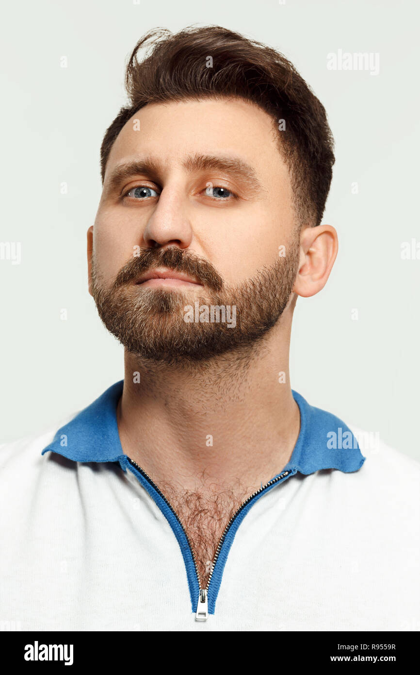 Serious man standing, looking at camera isolated on white studio ...