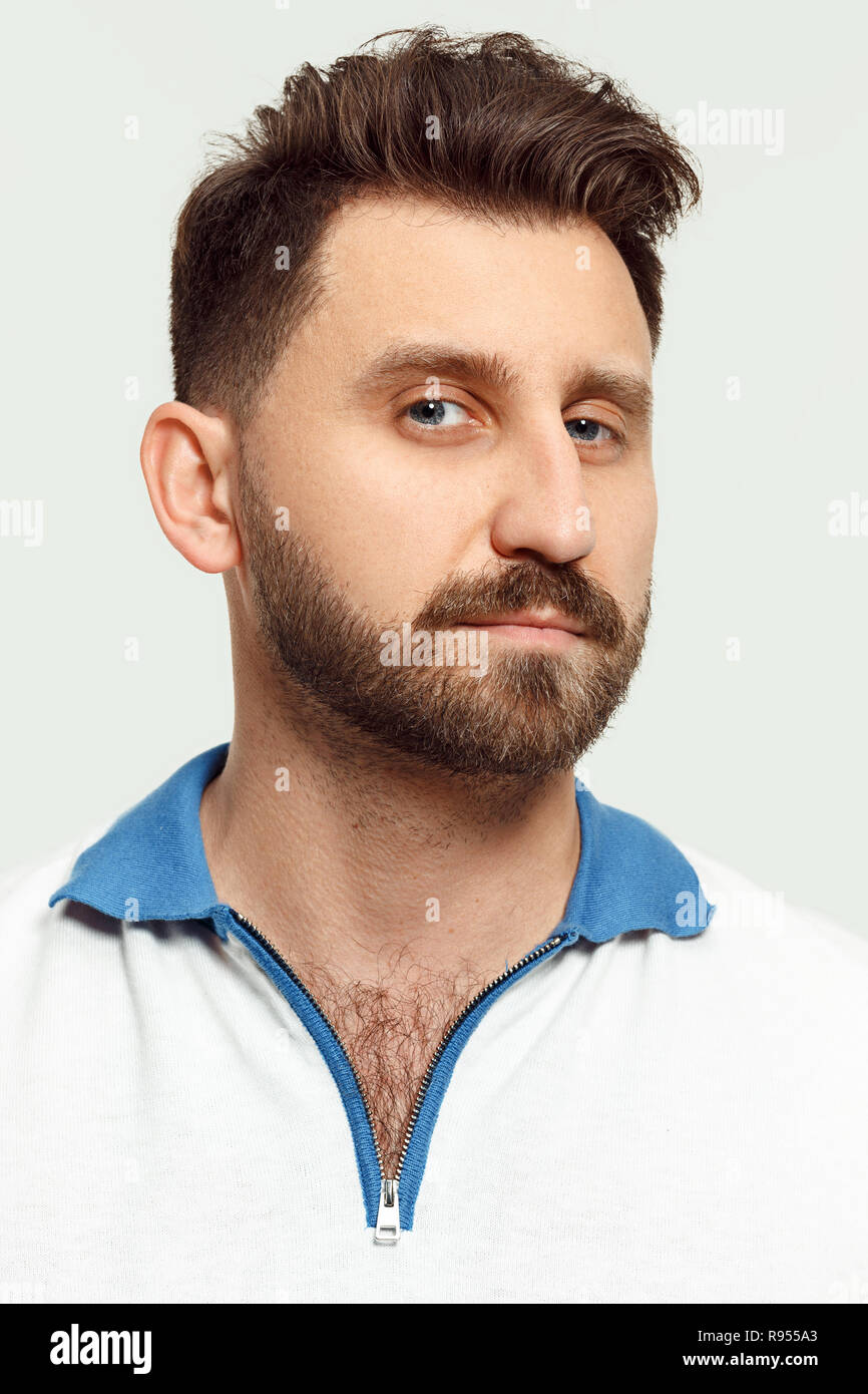 Serious man standing, looking at camera isolated on white studio ...