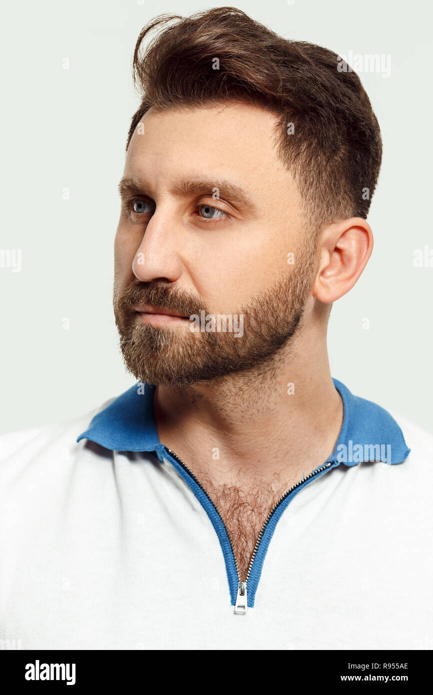 Serious man standing, looking at camera isolated on white studio ...