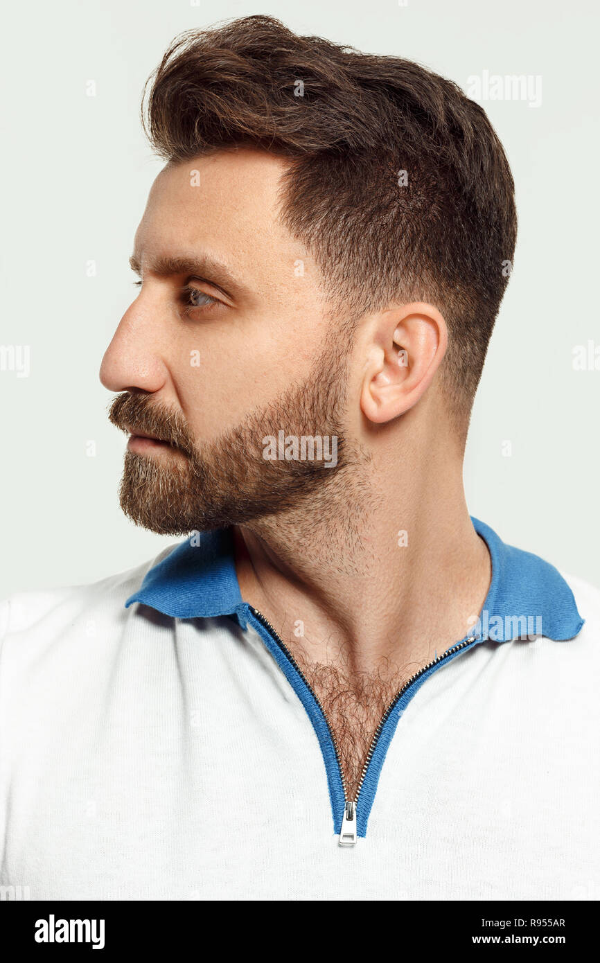 Serious man standing, looking at camera isolated on white studio ...