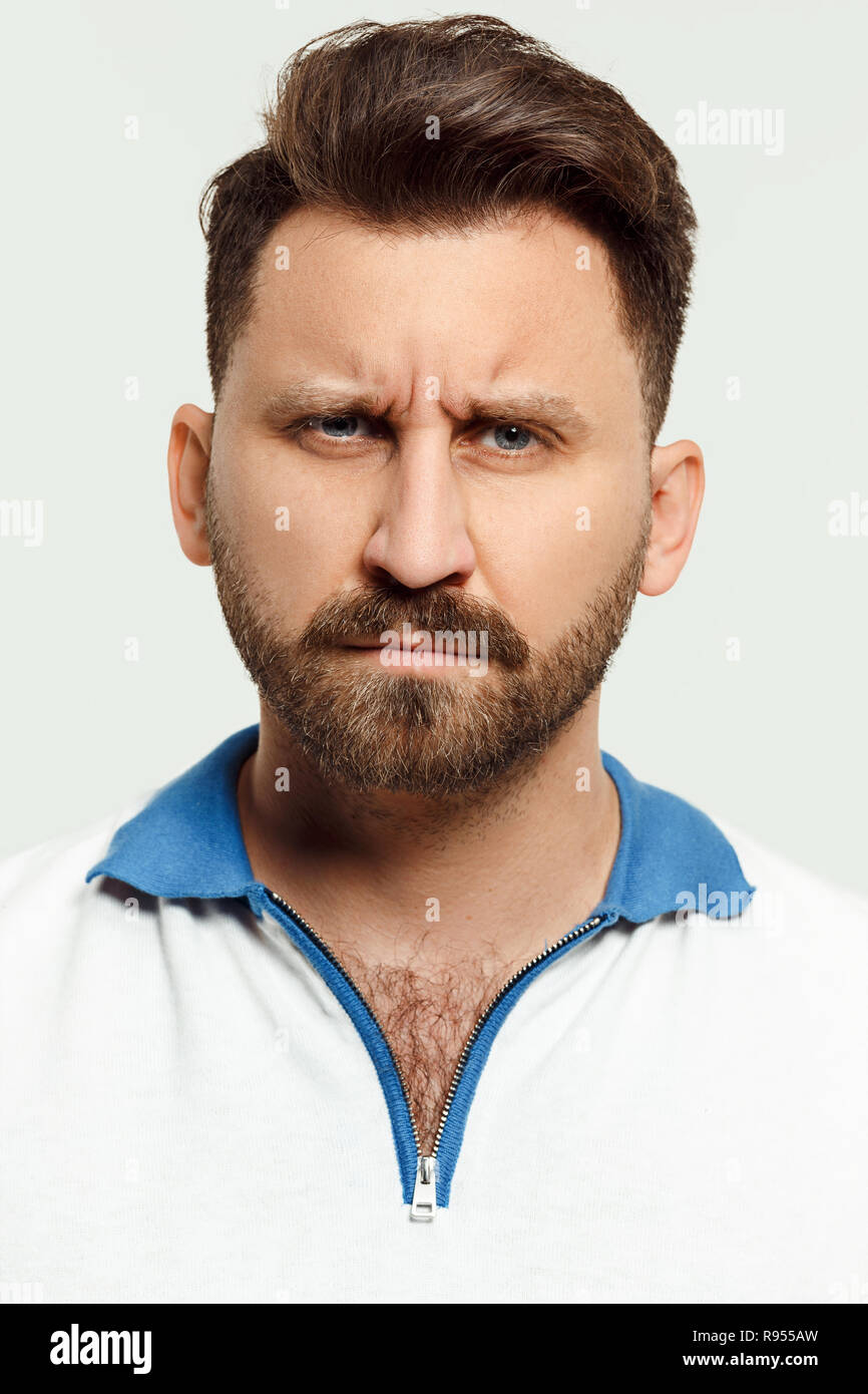 Serious man standing, looking at camera isolated on white studio ...