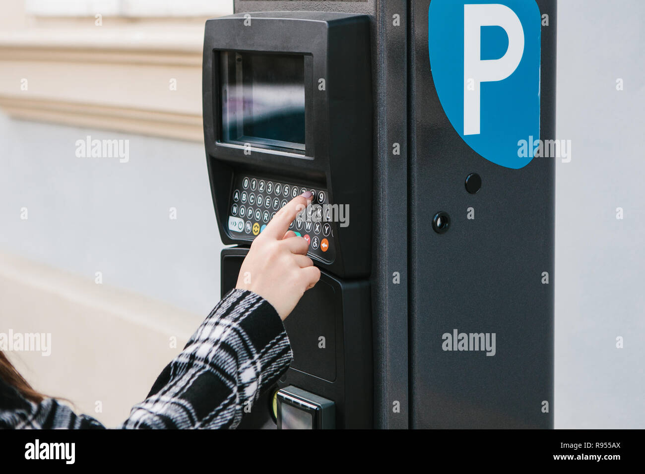 A modern terminal for paying for car parking. The person presses the ...