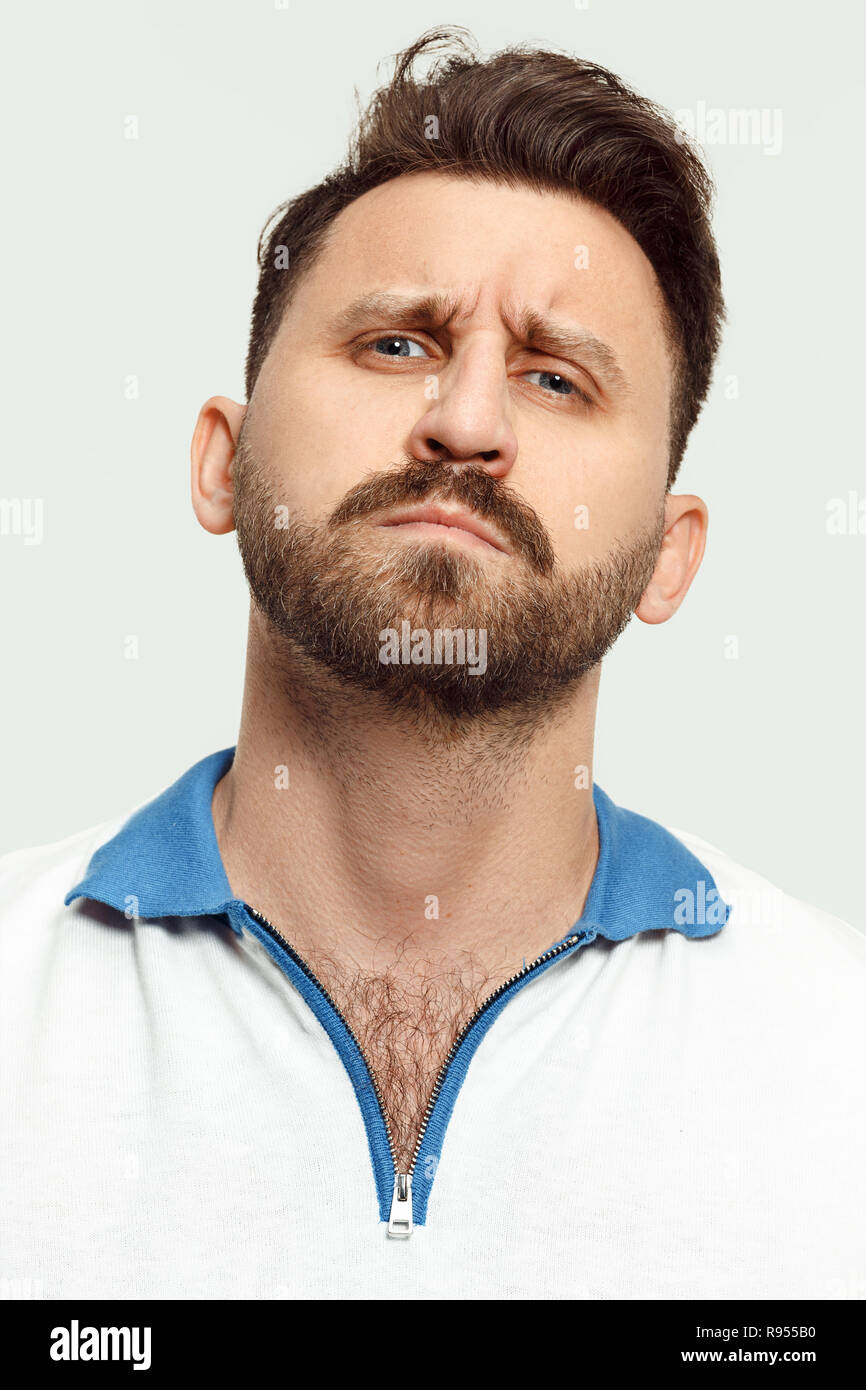 Serious man standing, looking at camera isolated on white studio ...
