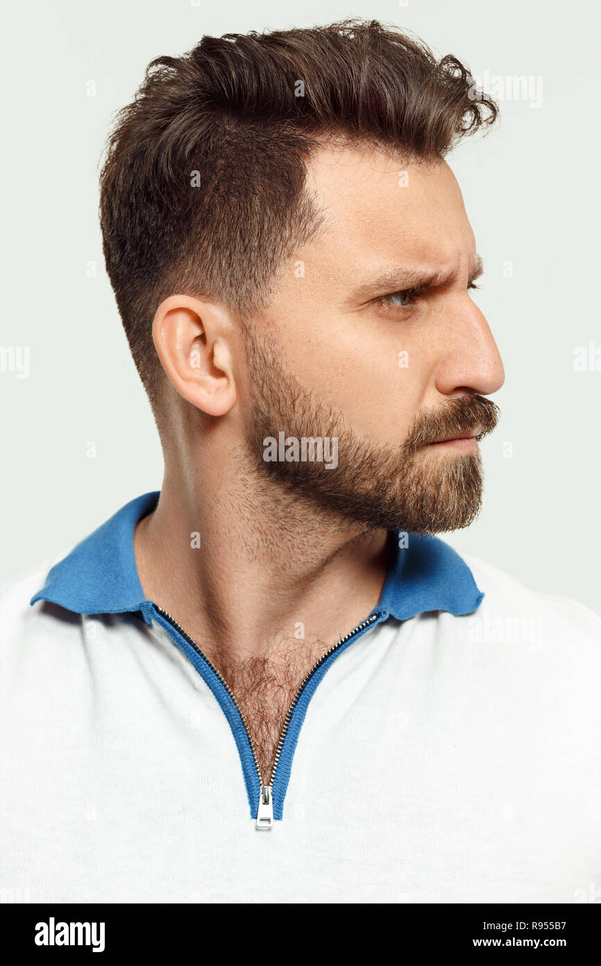 Serious man standing, looking at camera isolated on white studio ...