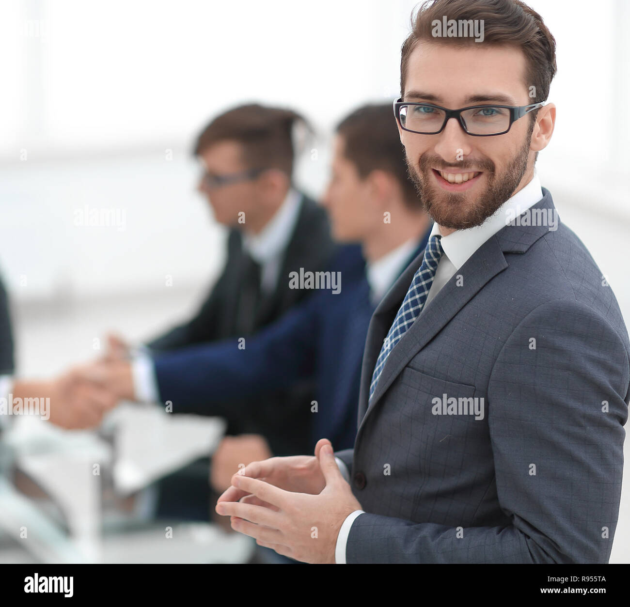 smiling businessman on blurred office background Stock Photo - Alamy