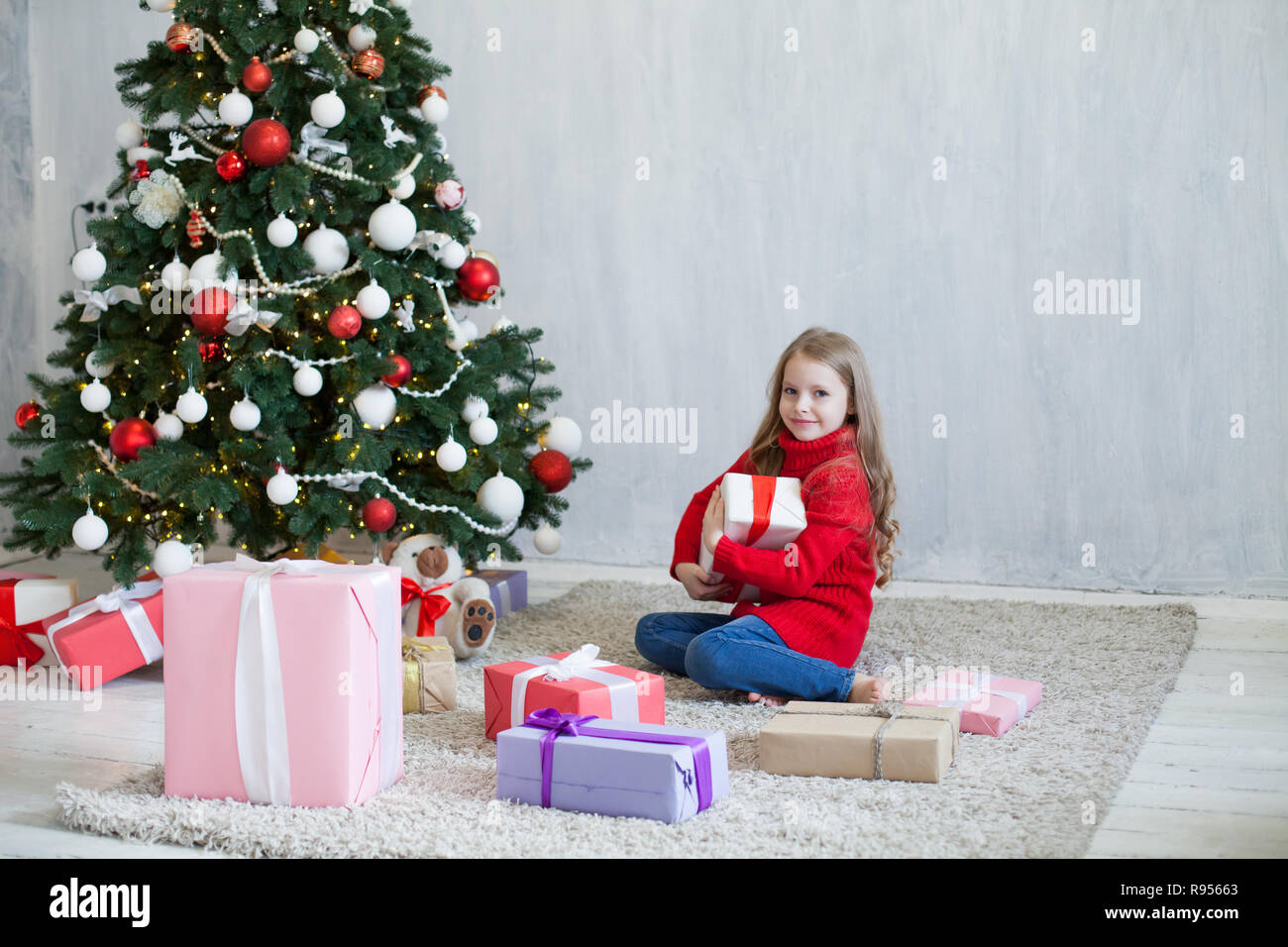 little girl opens Christmas presents new year tree decoration Stock ...