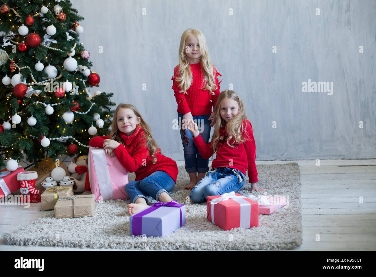 three girls blonde sisters girlfriends gift new year tree holiday ...