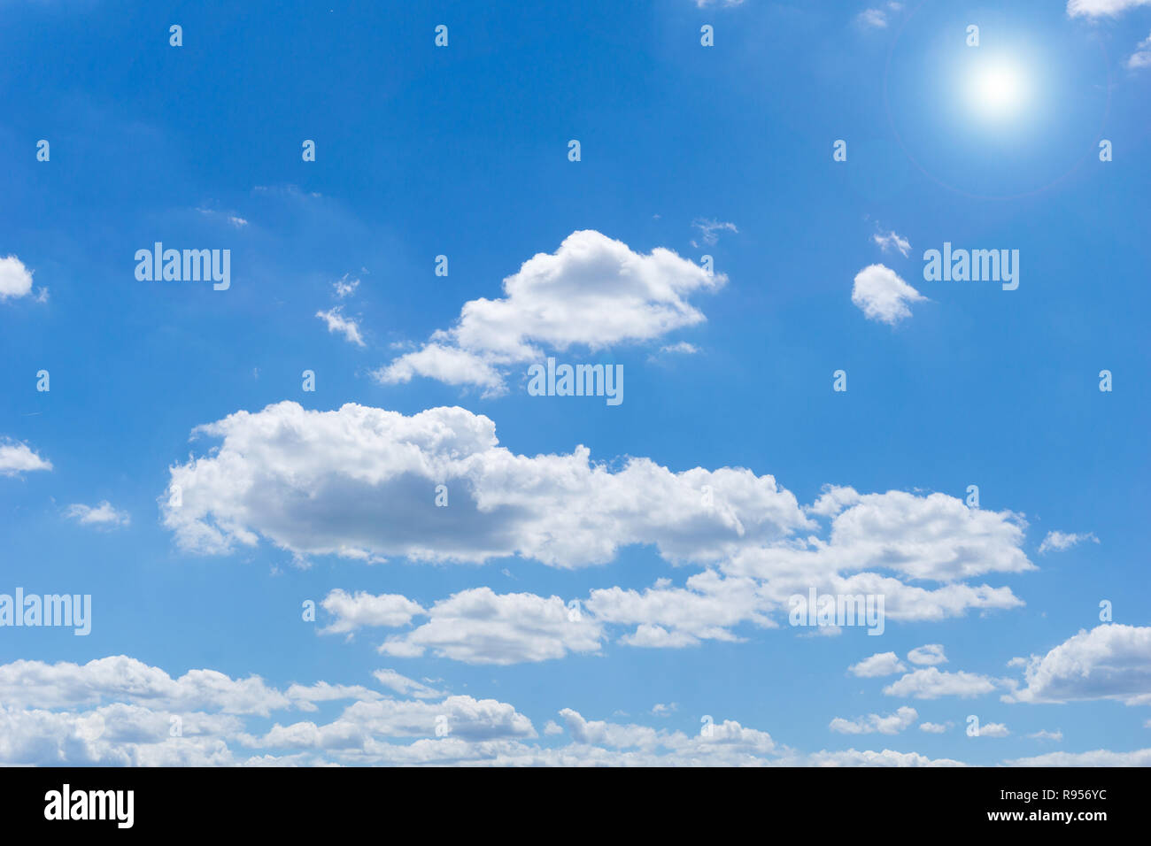 White fluffy clouds and sunshine on in front of blue sky Stock Photo ...