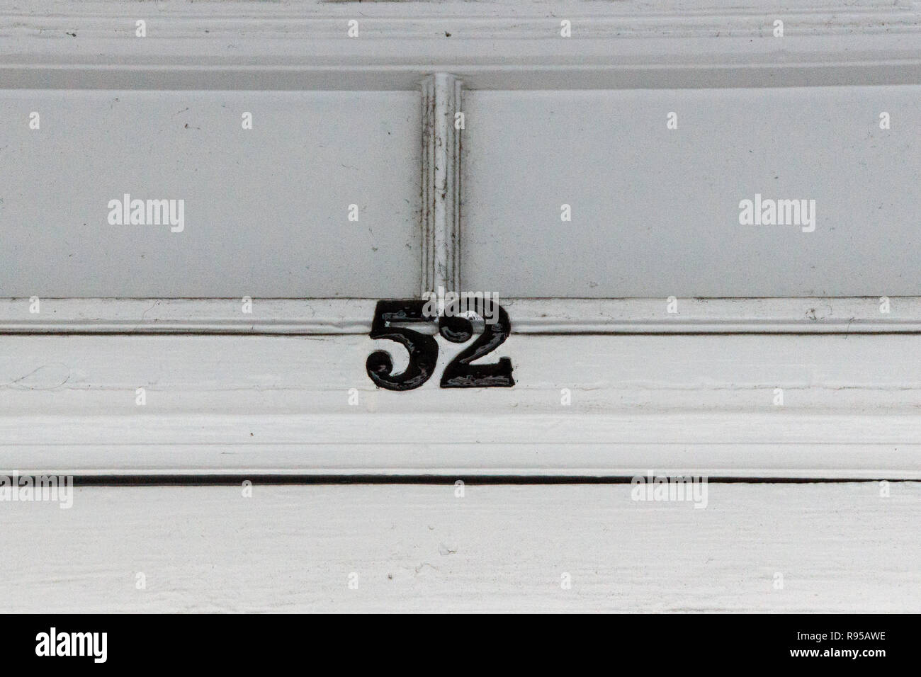 The house number 52 on a white painted door frame in Hertfordshire ...