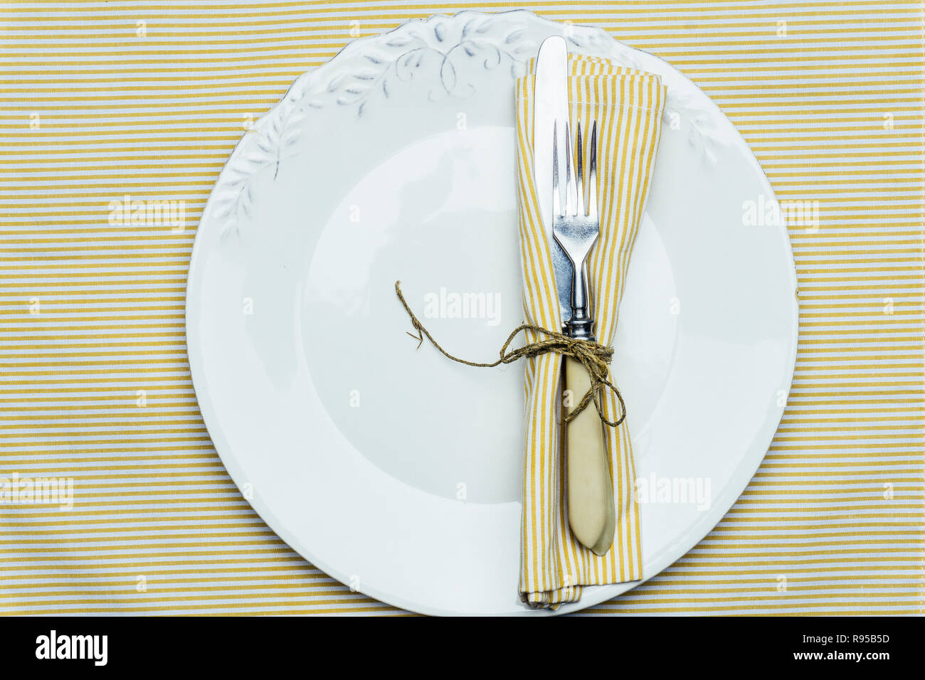 Empty white rustic plate on the background of a light striped ...