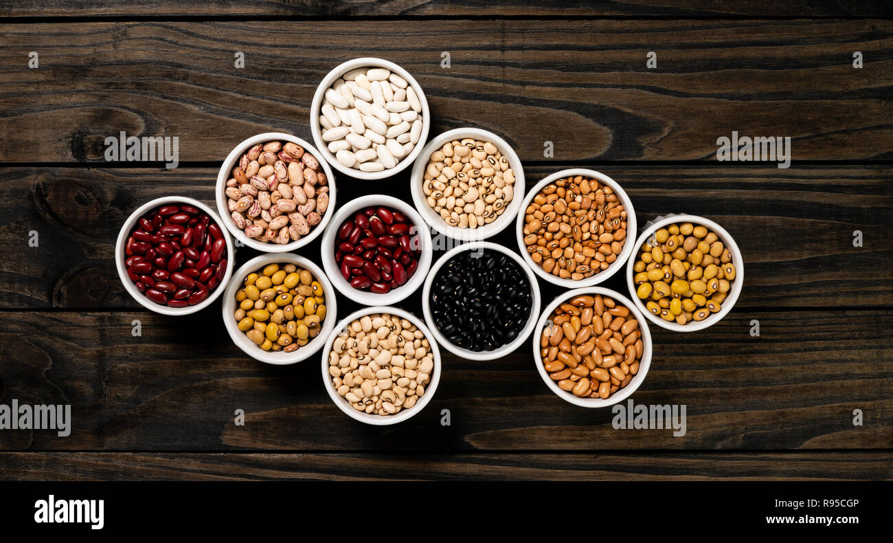 Assortment of beans in a pot. Wooden black background Stock Photo - Alamy