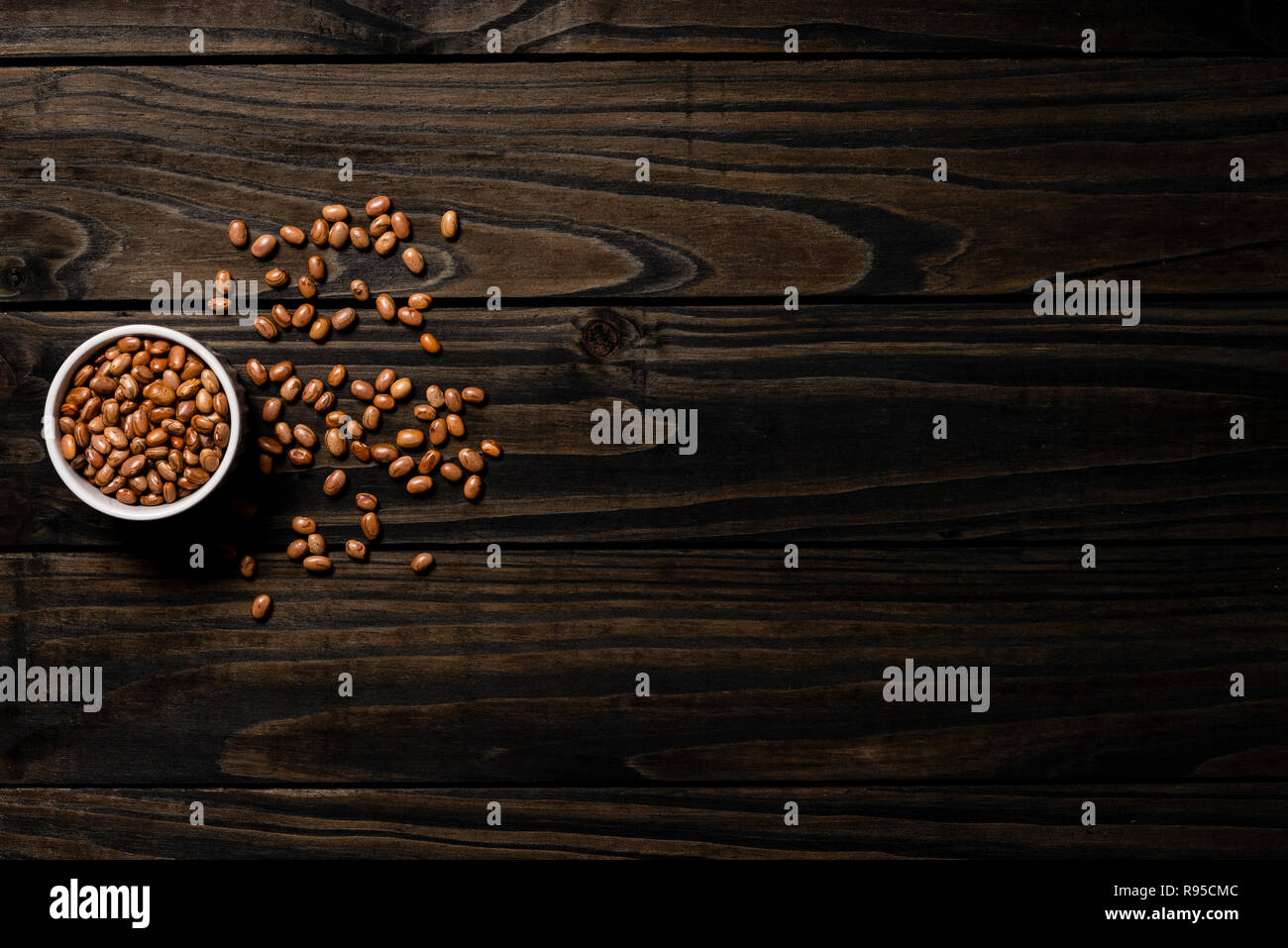 Carioca beans in pot. Wooden black background Stock Photo - Alamy