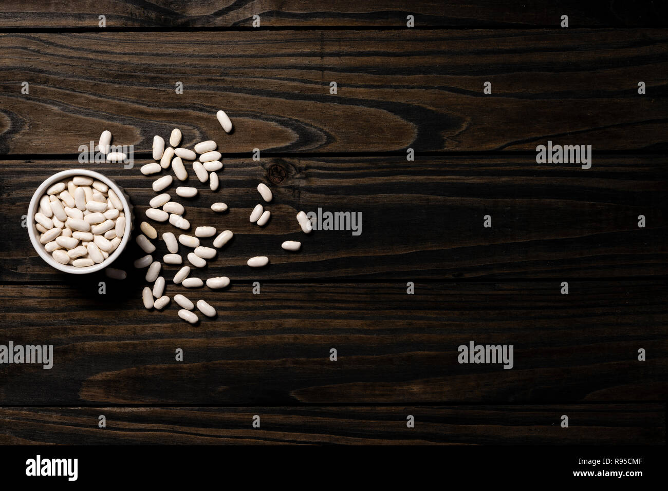 White beans in pot. Wooden black background Stock Photo - Alamy