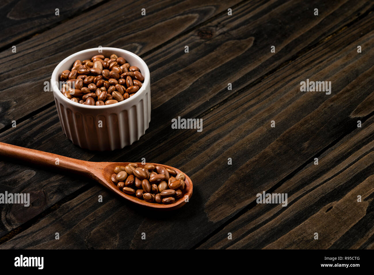 Carioca beans in pot. Wooden black background Stock Photo - Alamy