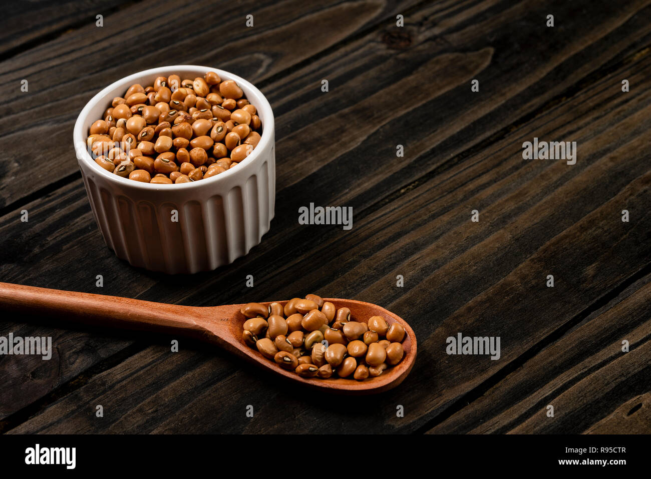 Bean ropes in pot. Wooden black background Stock Photo - Alamy