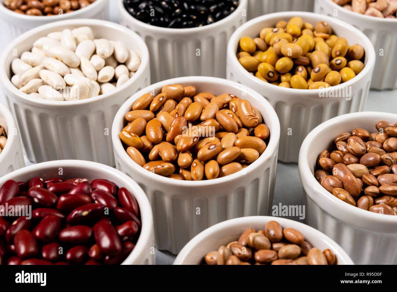Assortment of beans in pots on gray background Stock Photo - Alamy