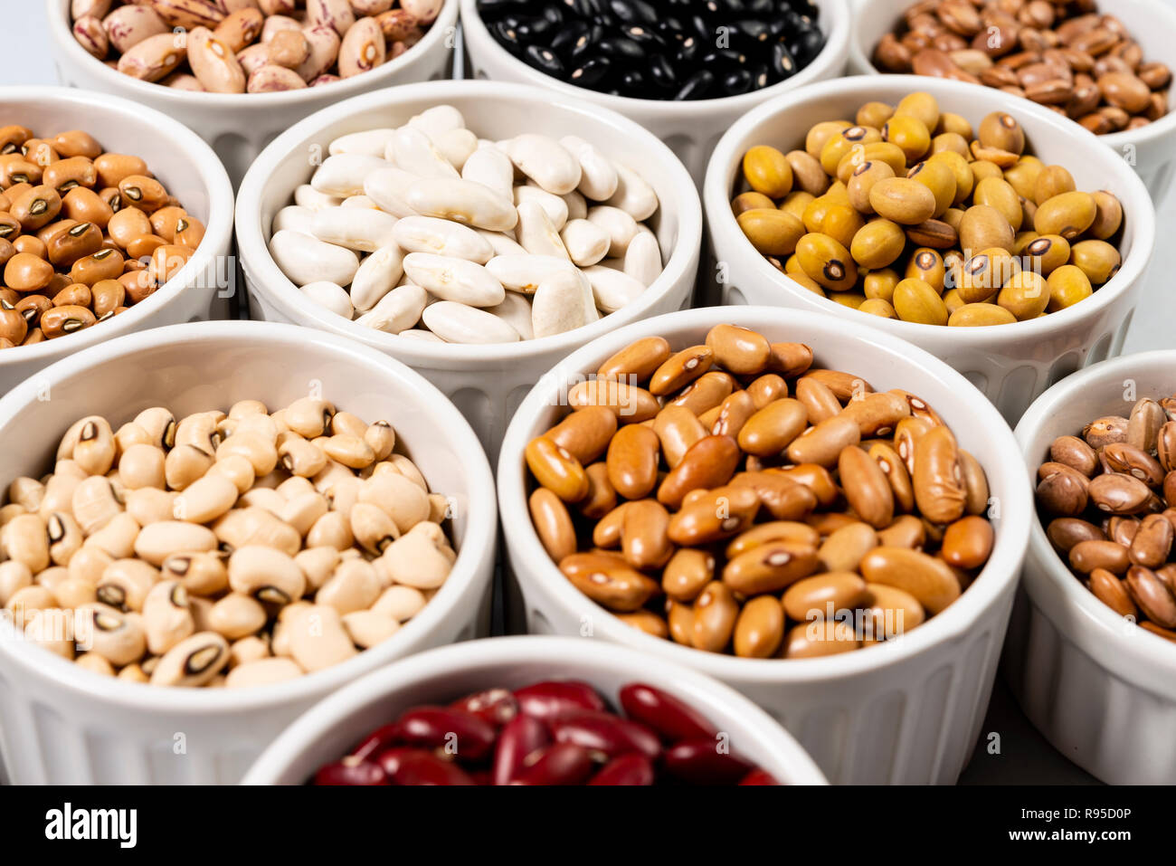 Assortment of beans in pots on gray background Stock Photo - Alamy