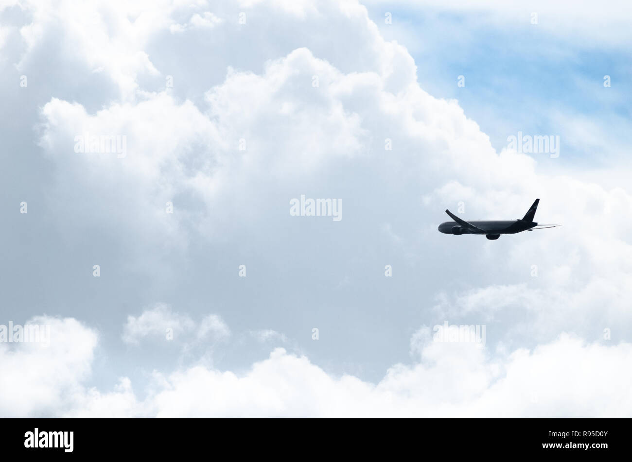 Boeing 777 Flying into some White Clouds Stock Photo - Alamy