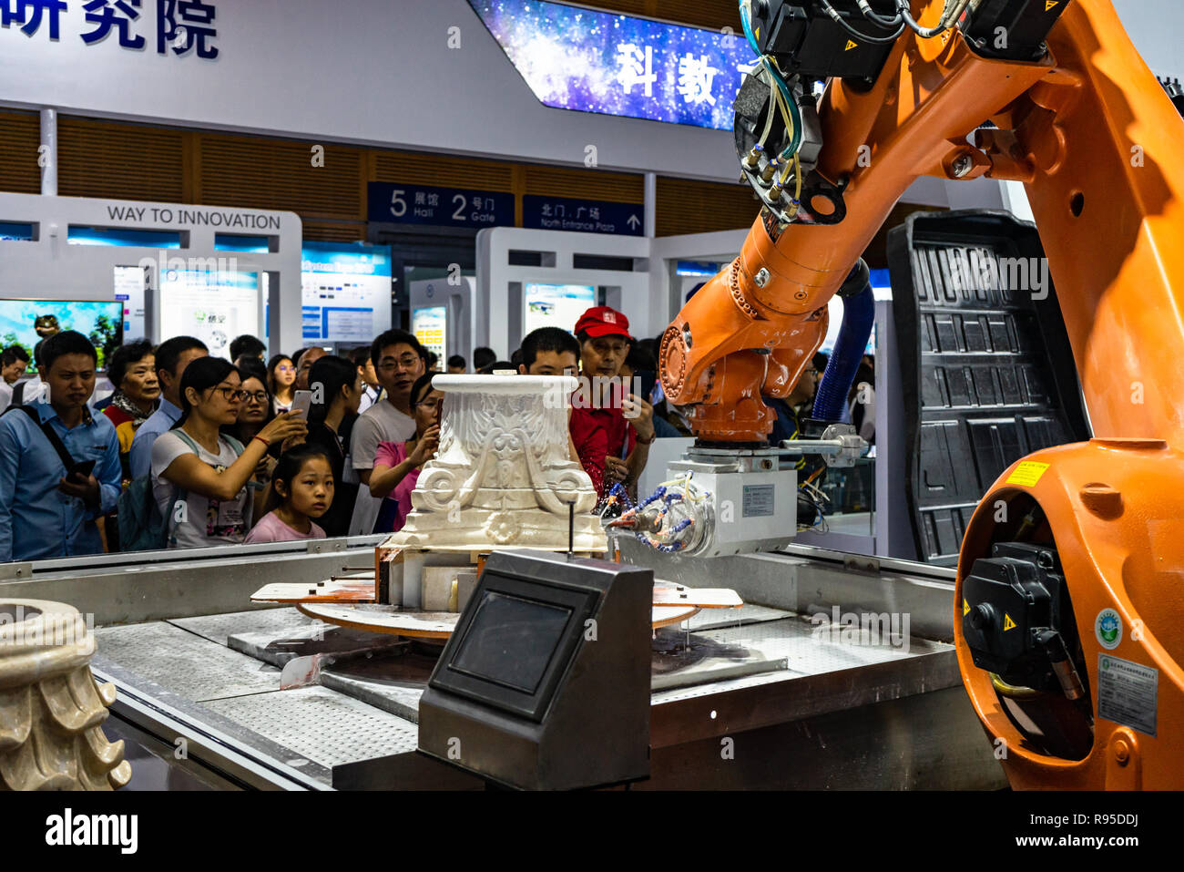 Industrial robot carving and engraving plaster pedestal at tech fair in ...