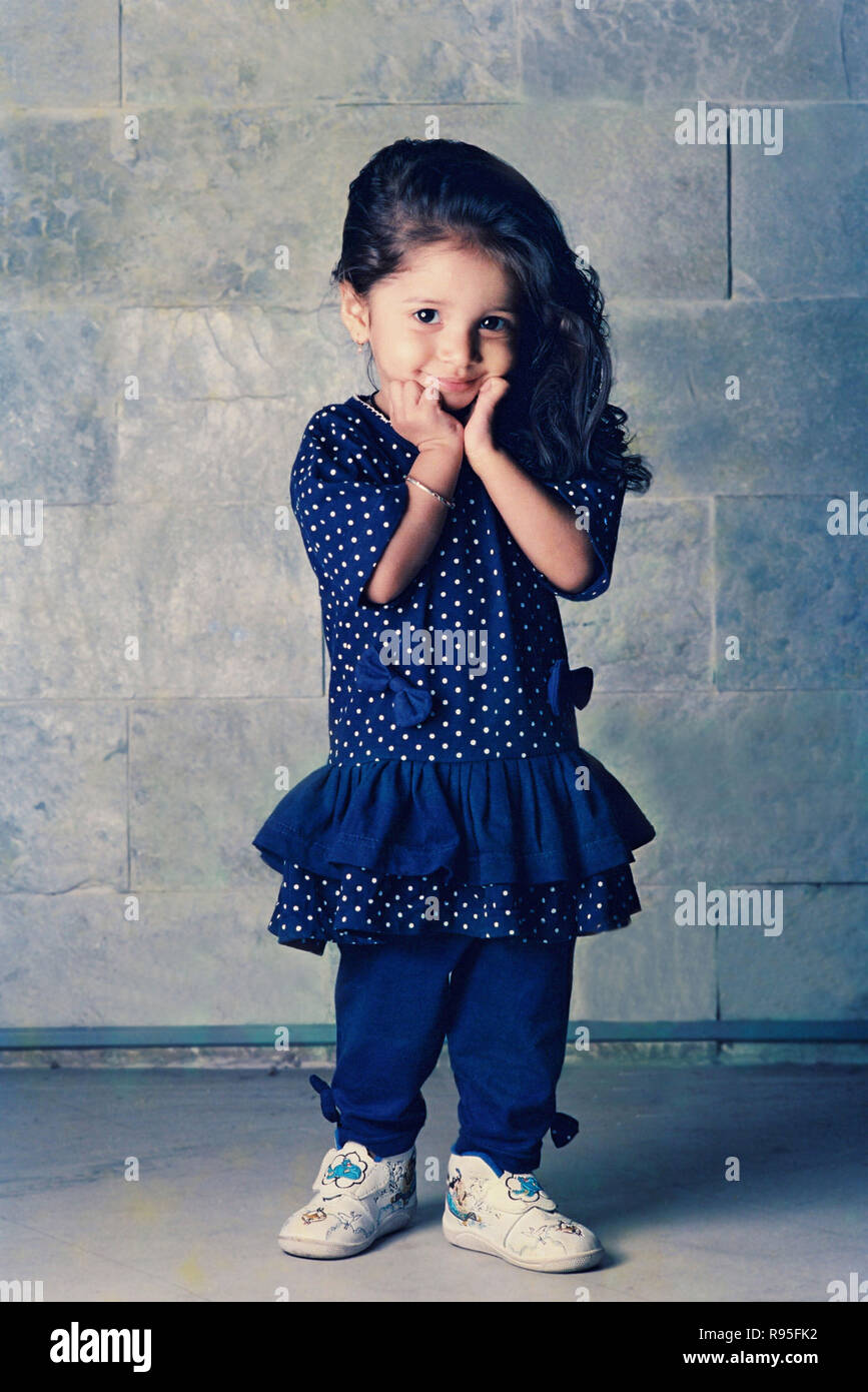 Baby girl small child wearing blue polka dot frock Stock Photo - Alamy