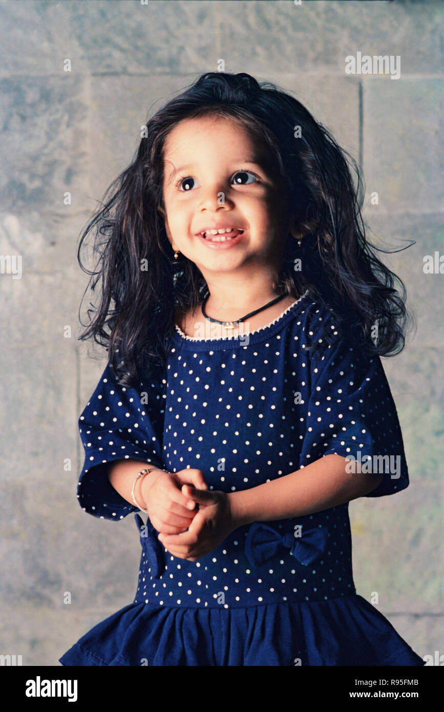 Baby girl child standing looking up Stock Photo - Alamy