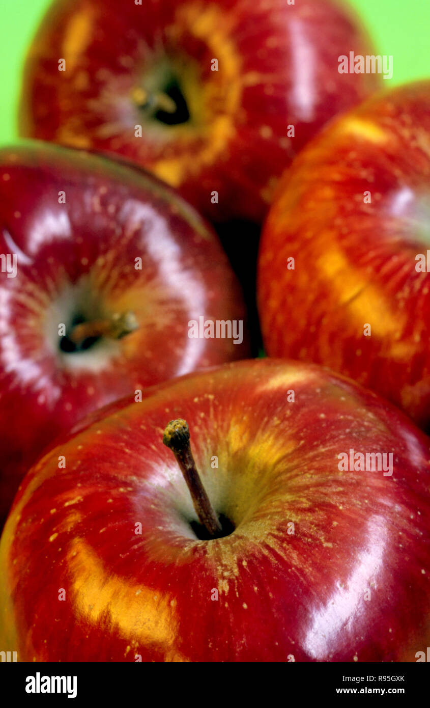 Four apples on green background Stock Photo - Alamy