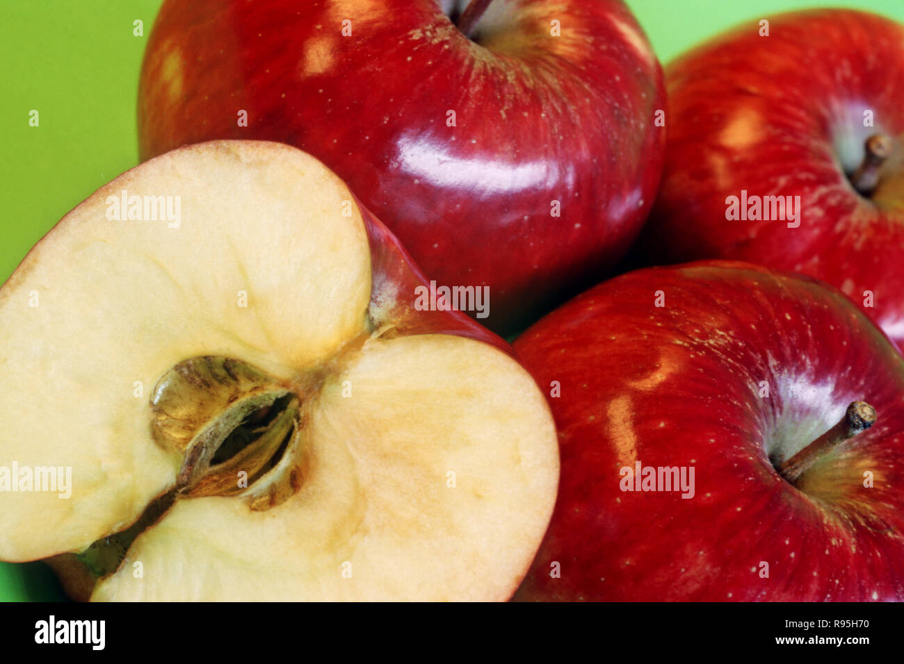 Apple one cut and three full uncut apples on green background Stock ...