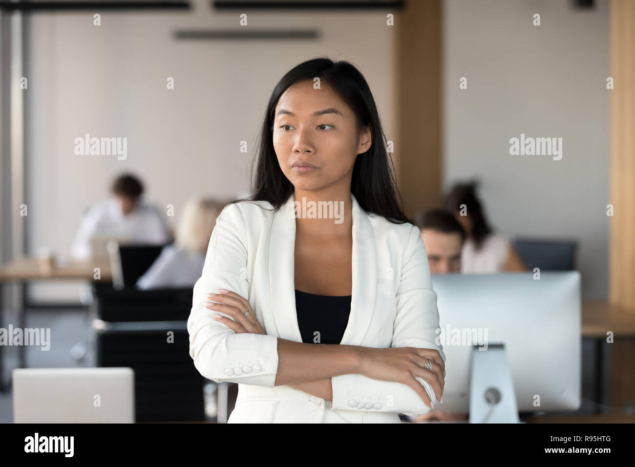Serious asian female employee standing in coworking office and t Stock ...